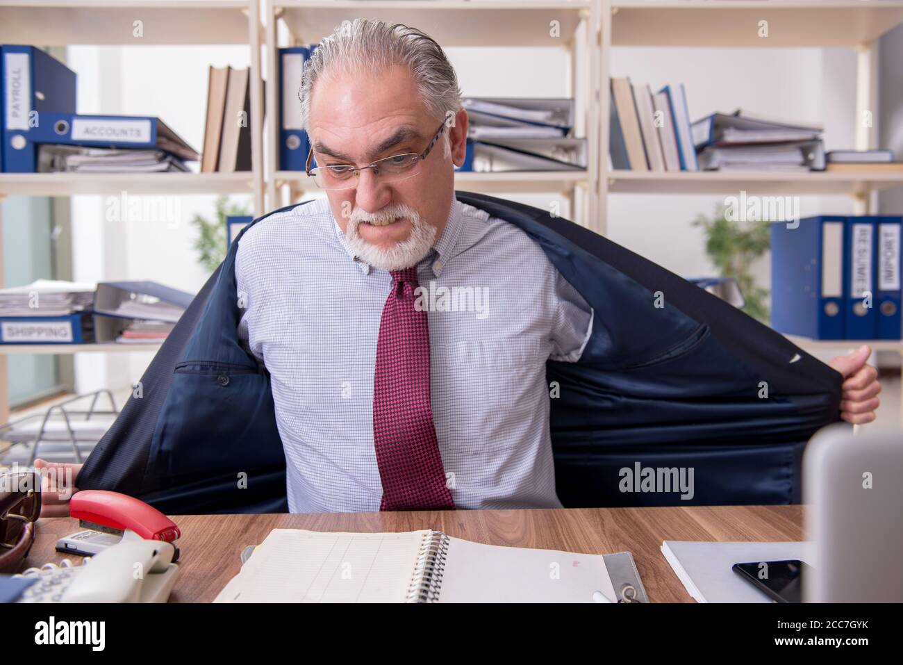 Old employee unhappy with excessive work Stock Photo - Alamy