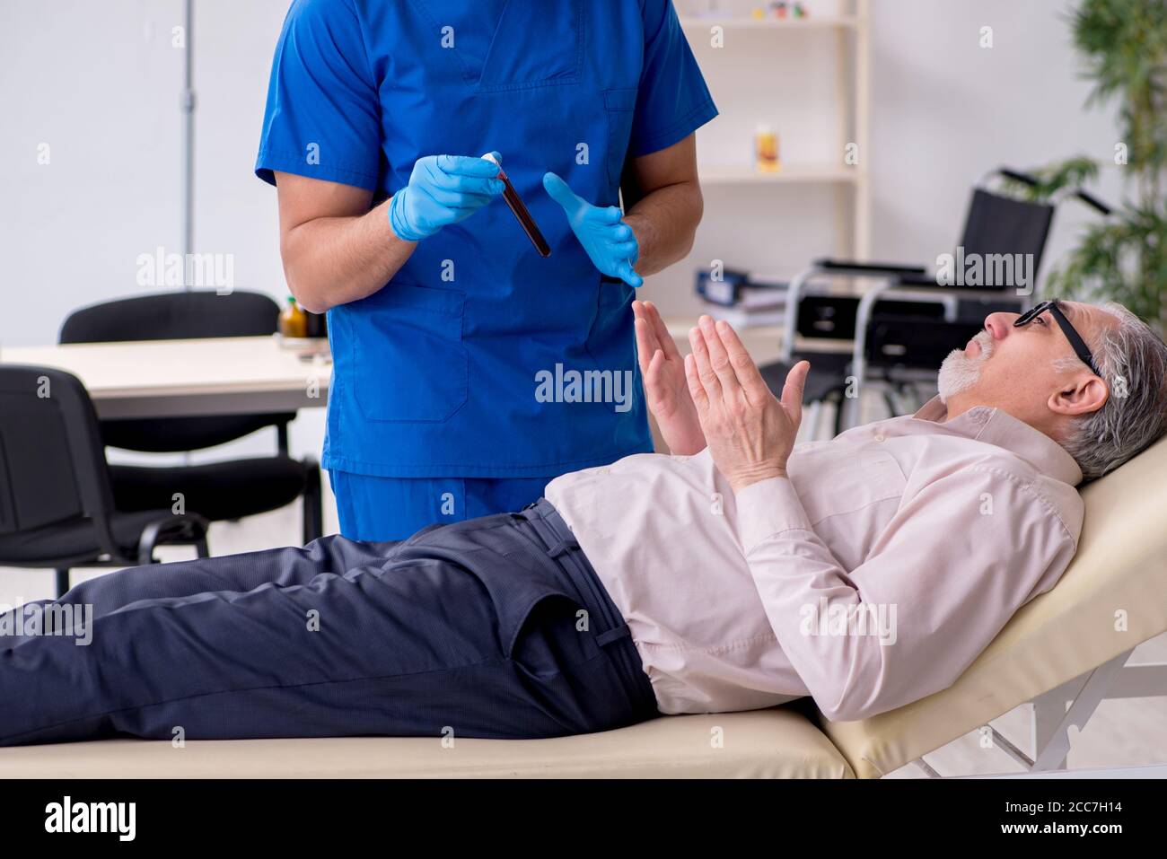 Old patient visiting young doctor in blood sampling concept Stock Photo ...