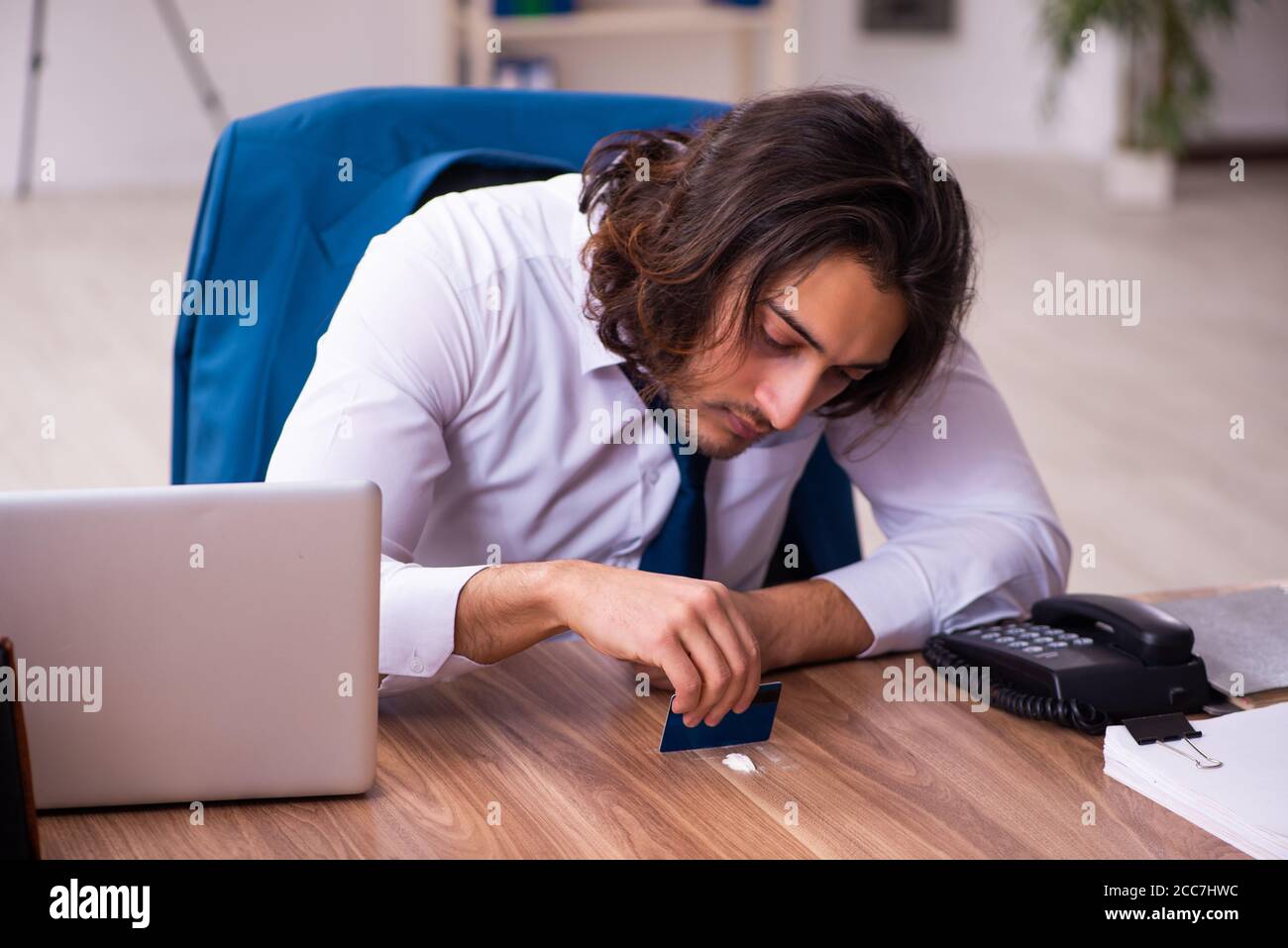 Drug addicted employee working in the office Stock Photo - Alamy