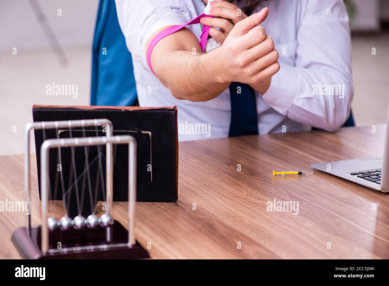 Drug addicted employee working in the office Stock Photo - Alamy