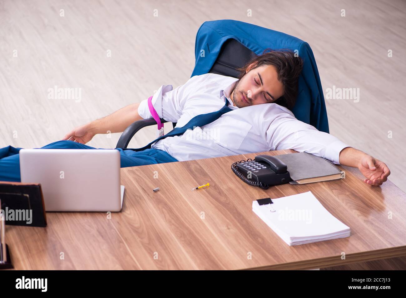 Drug addicted employee working in the office Stock Photo - Alamy