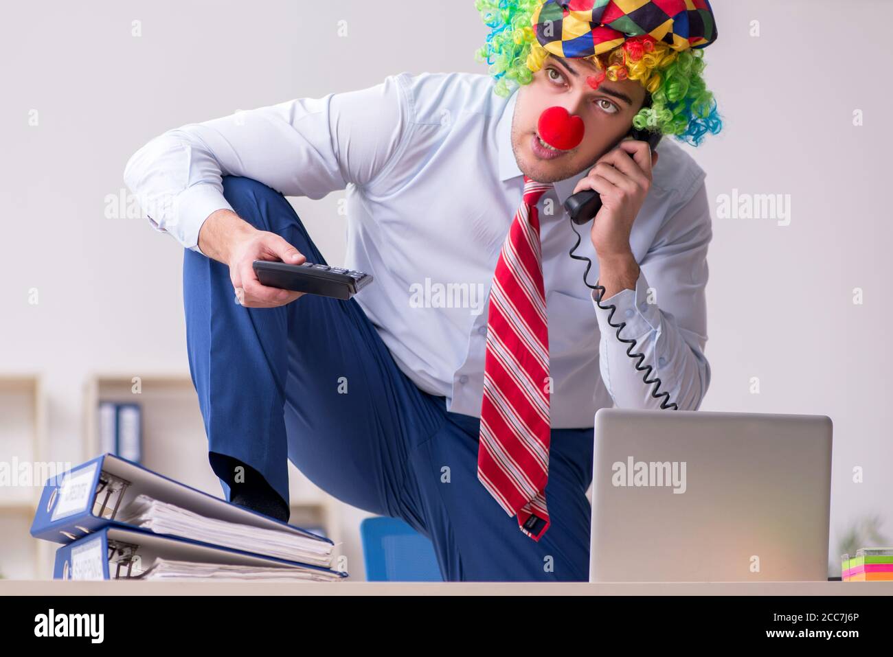 Funny employee clown working in the office room Stock Photo - Alamy