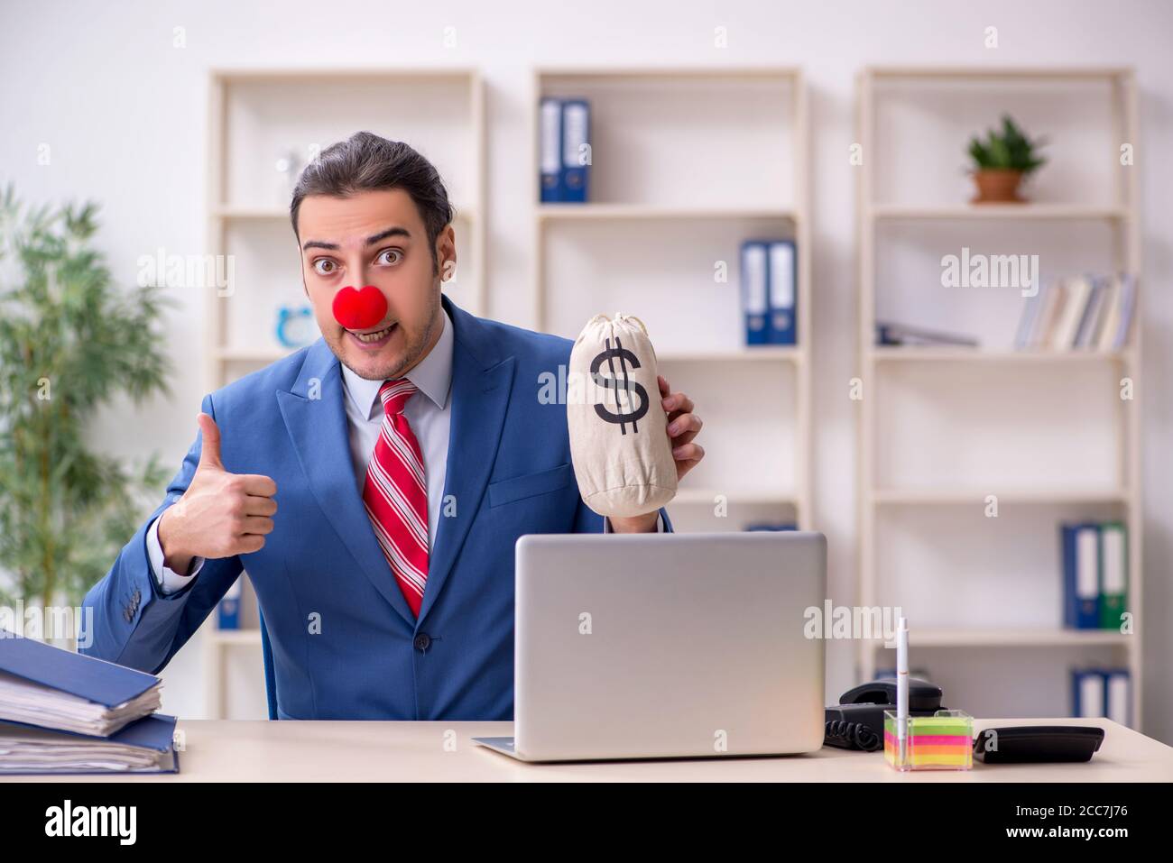 Funny employee clown working in the office room Stock Photo - Alamy