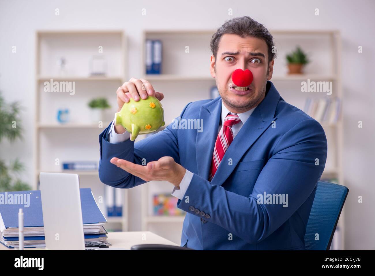 Funny employee clown working in the office room Stock Photo - Alamy