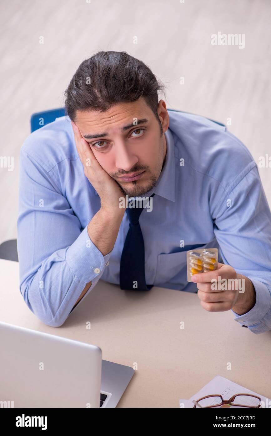 Sick male employee suffering at the workplace Stock Photo - Alamy