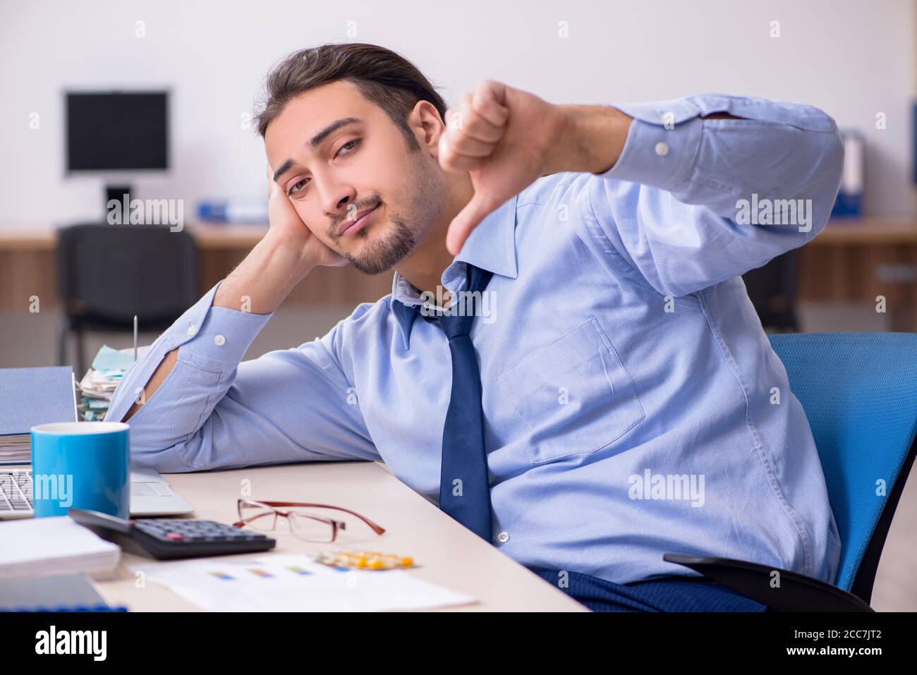 Sick male employee suffering at the workplace Stock Photo - Alamy