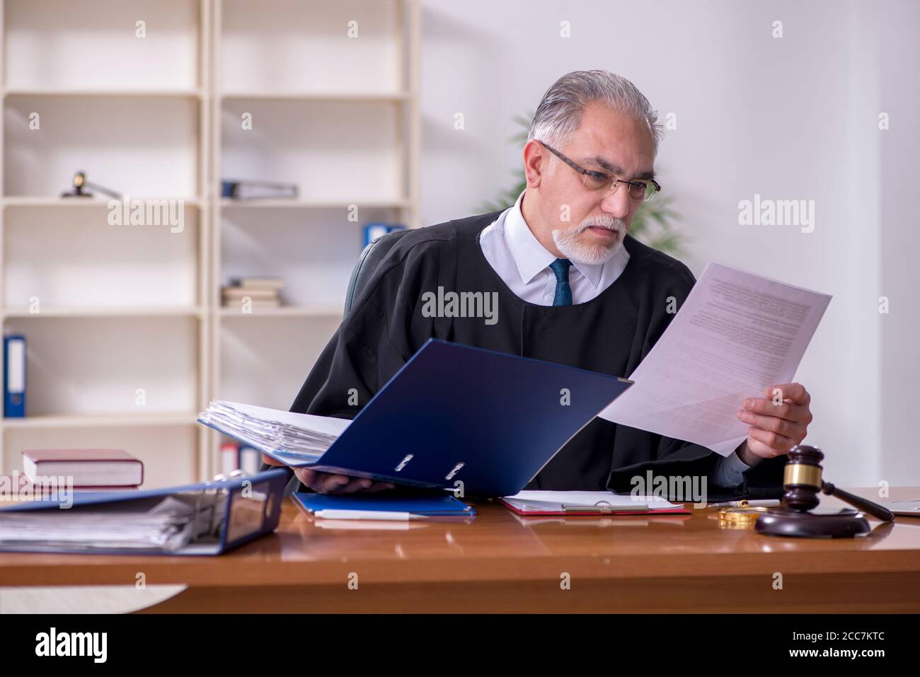 Old male judge working in the courthouse Stock Photo - Alamy
