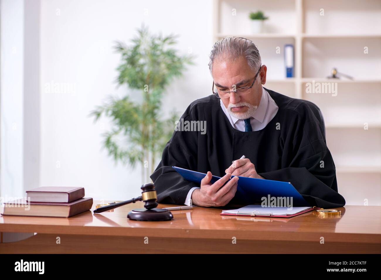 Old male judge working in the courthouse Stock Photo - Alamy