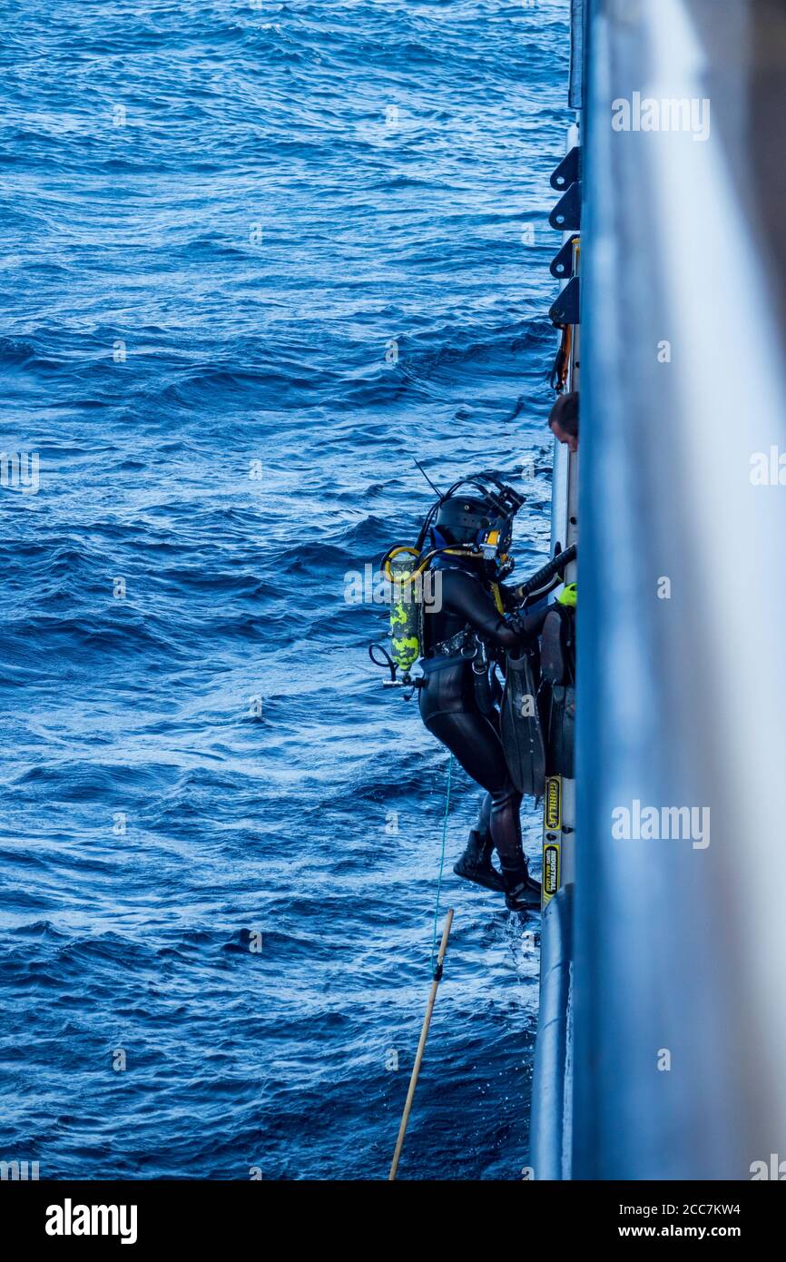 Commercial diver with hull scraper cleaning the hull of Ponant's Le ...