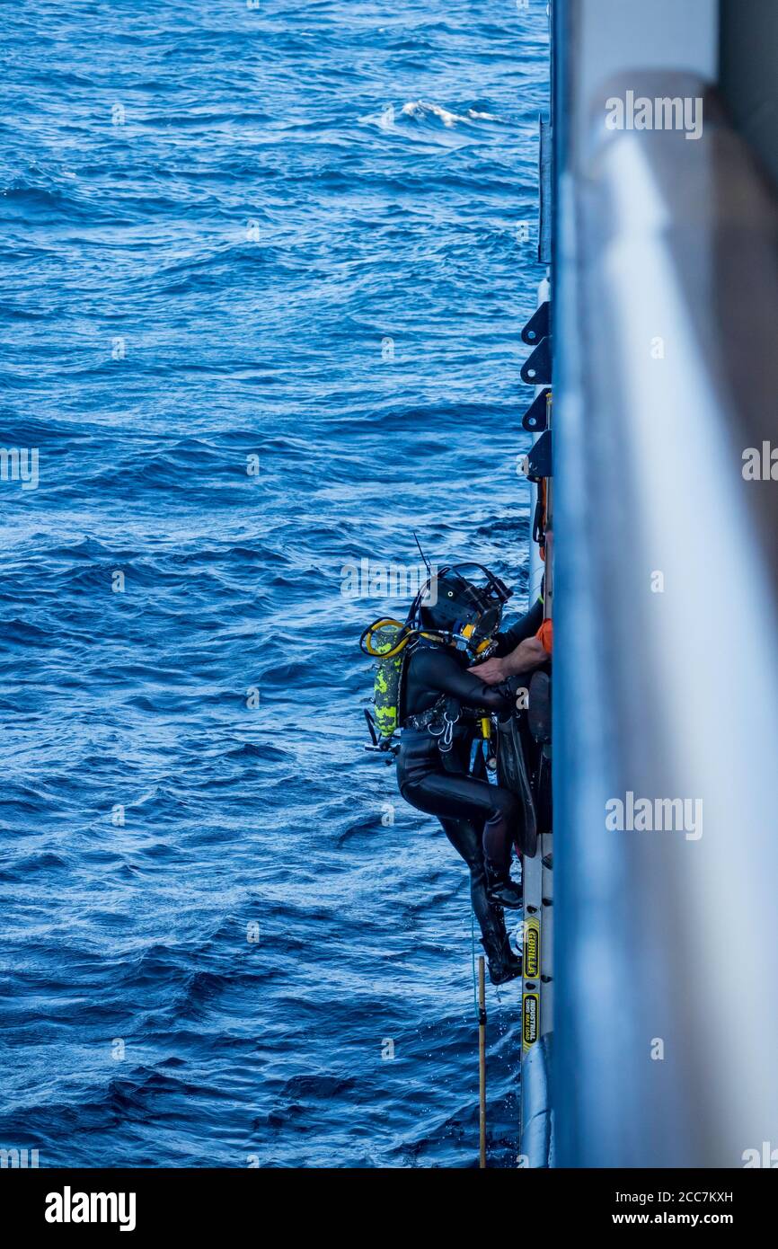 Commercial diver with hull scraper cleaning the hull of Ponant's Le ...