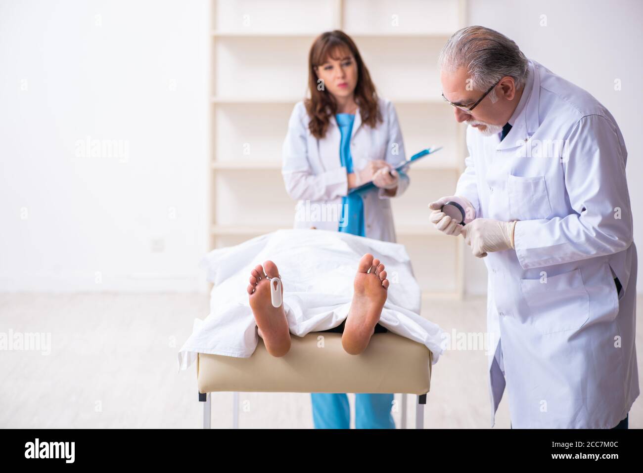Police coroner examining dead body corpse in the morgue Stock Photo - Alamy