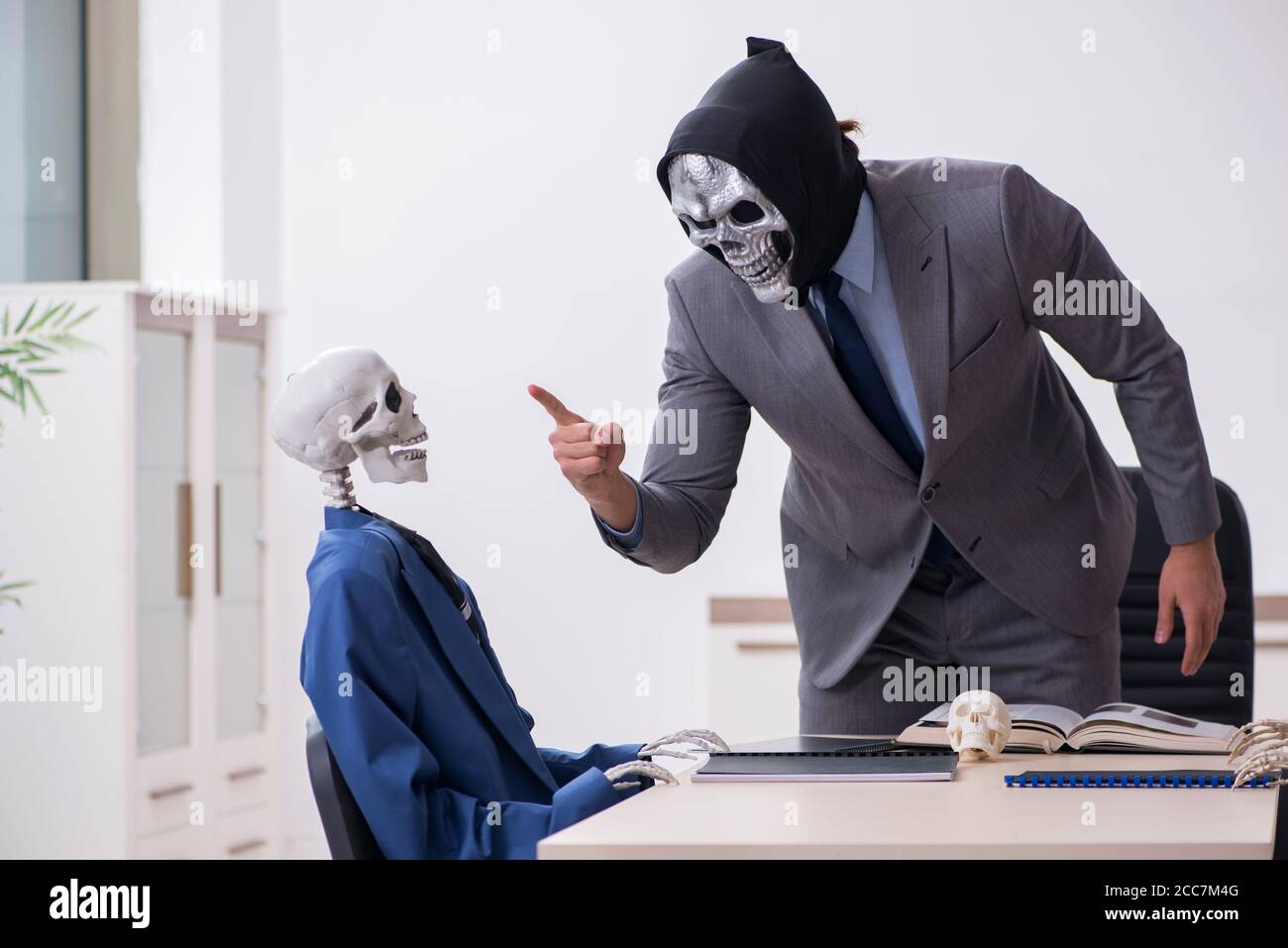 Funny business meeting with the devil and skeletons Stock Photo - Alamy