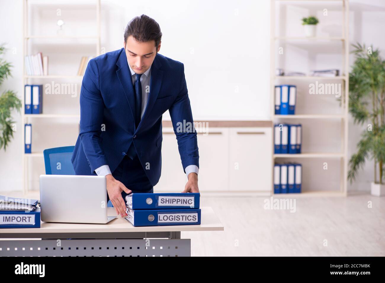 Young logistics specialist working in the office Stock Photo - Alamy
