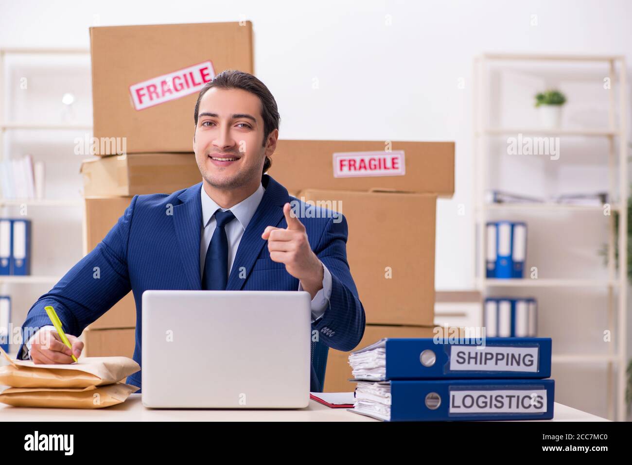 Young logistics specialist working in the office Stock Photo - Alamy