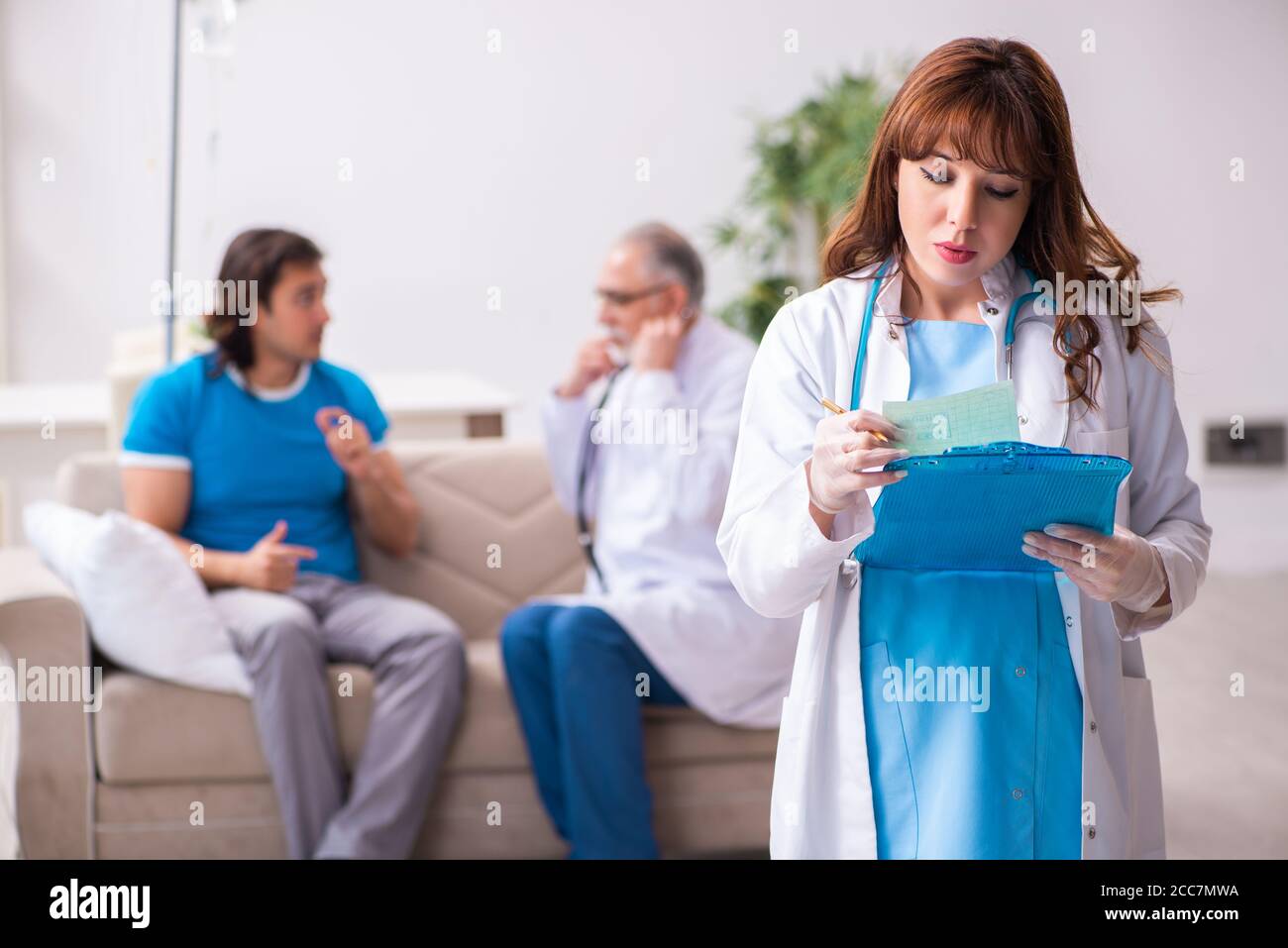 Two doctors visiting sick man at home Stock Photo - Alamy
