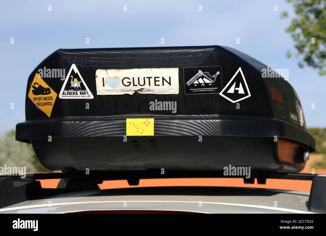 A roof cargo box with decals including one declaring a love for gluten ...