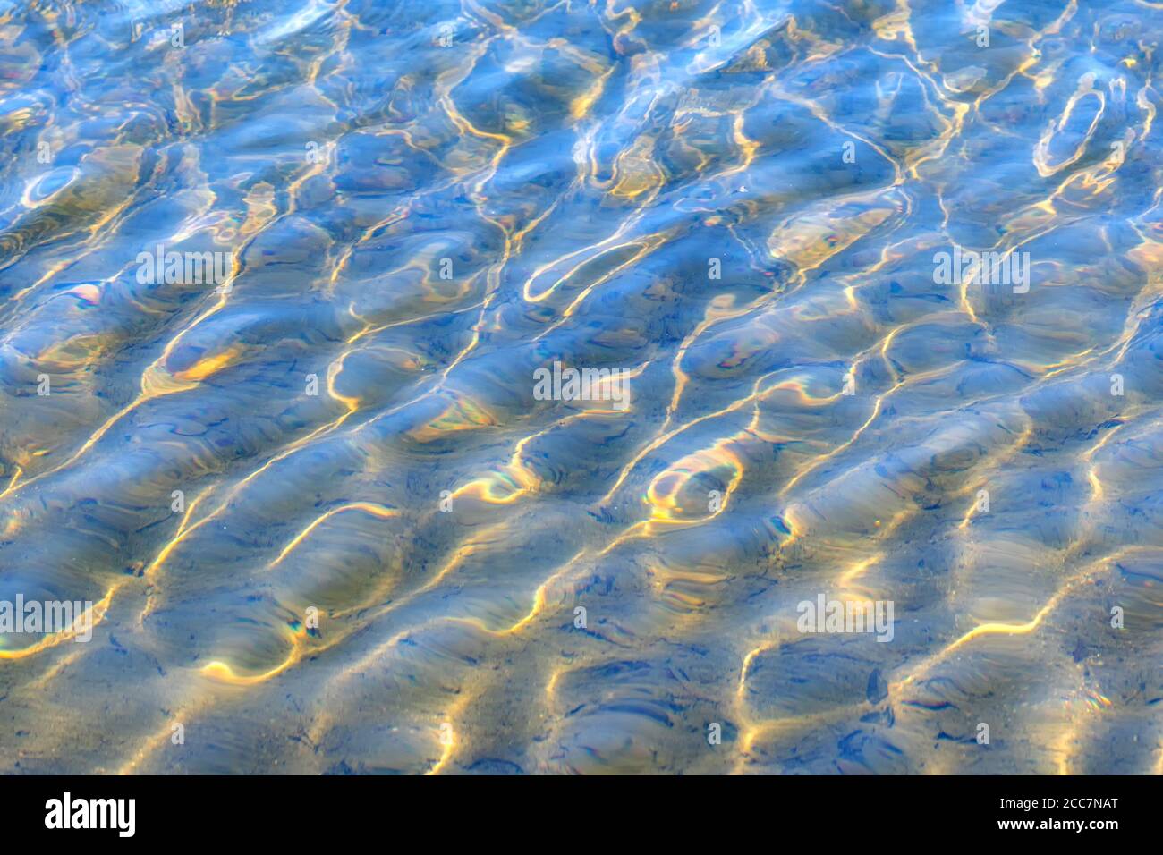 Sunlit ripple marks in shallow water. The bright ripples are caused sun ...