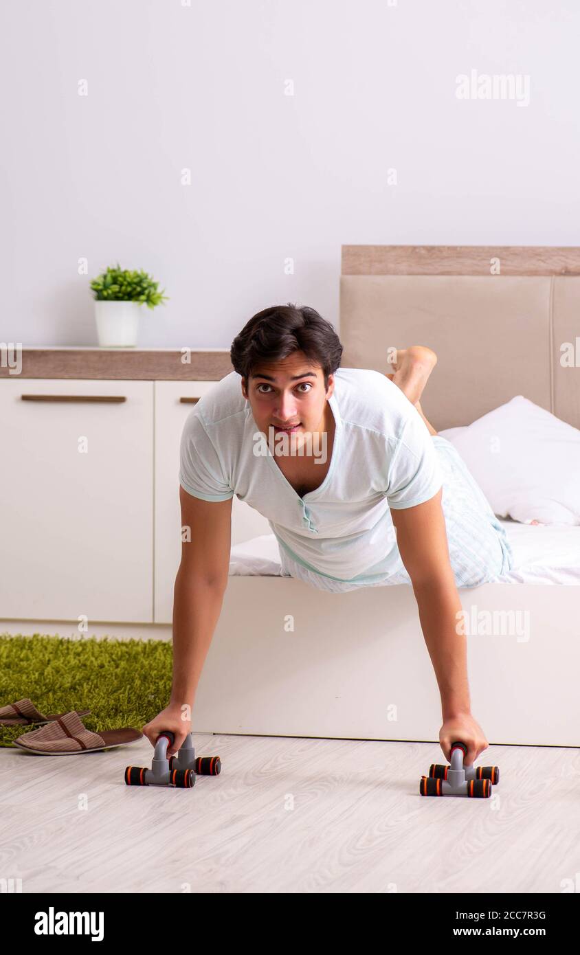 The young man doing morning routine in bedroom Stock Photo - Alamy