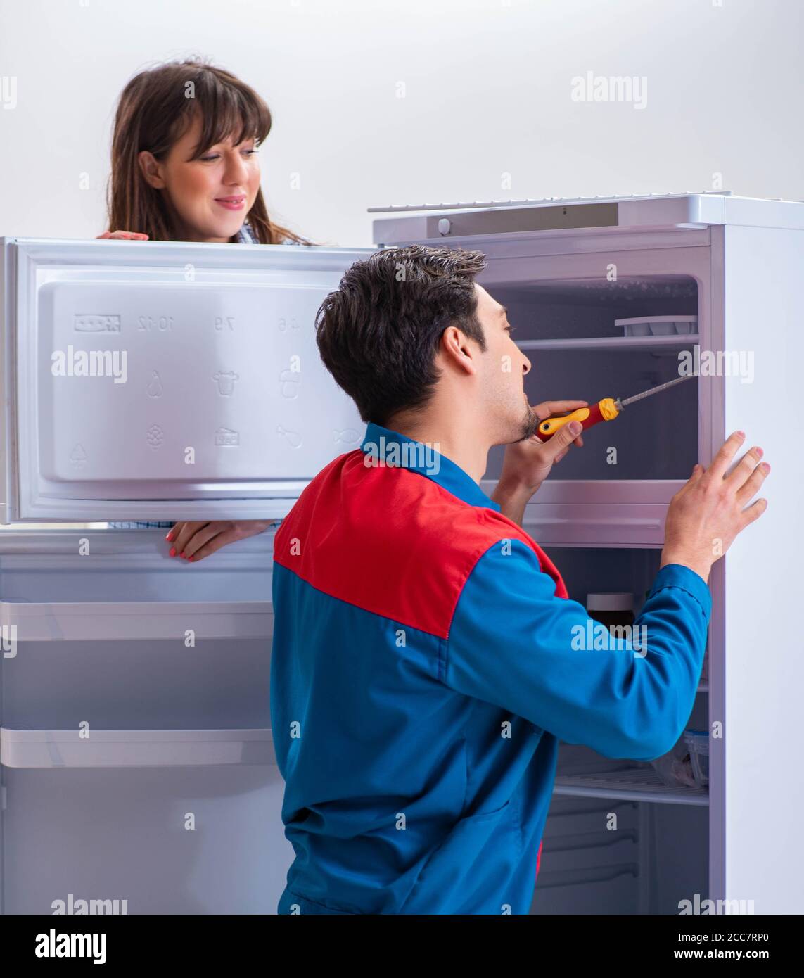 The man repairing fridge with customer Stock Photo - Alamy