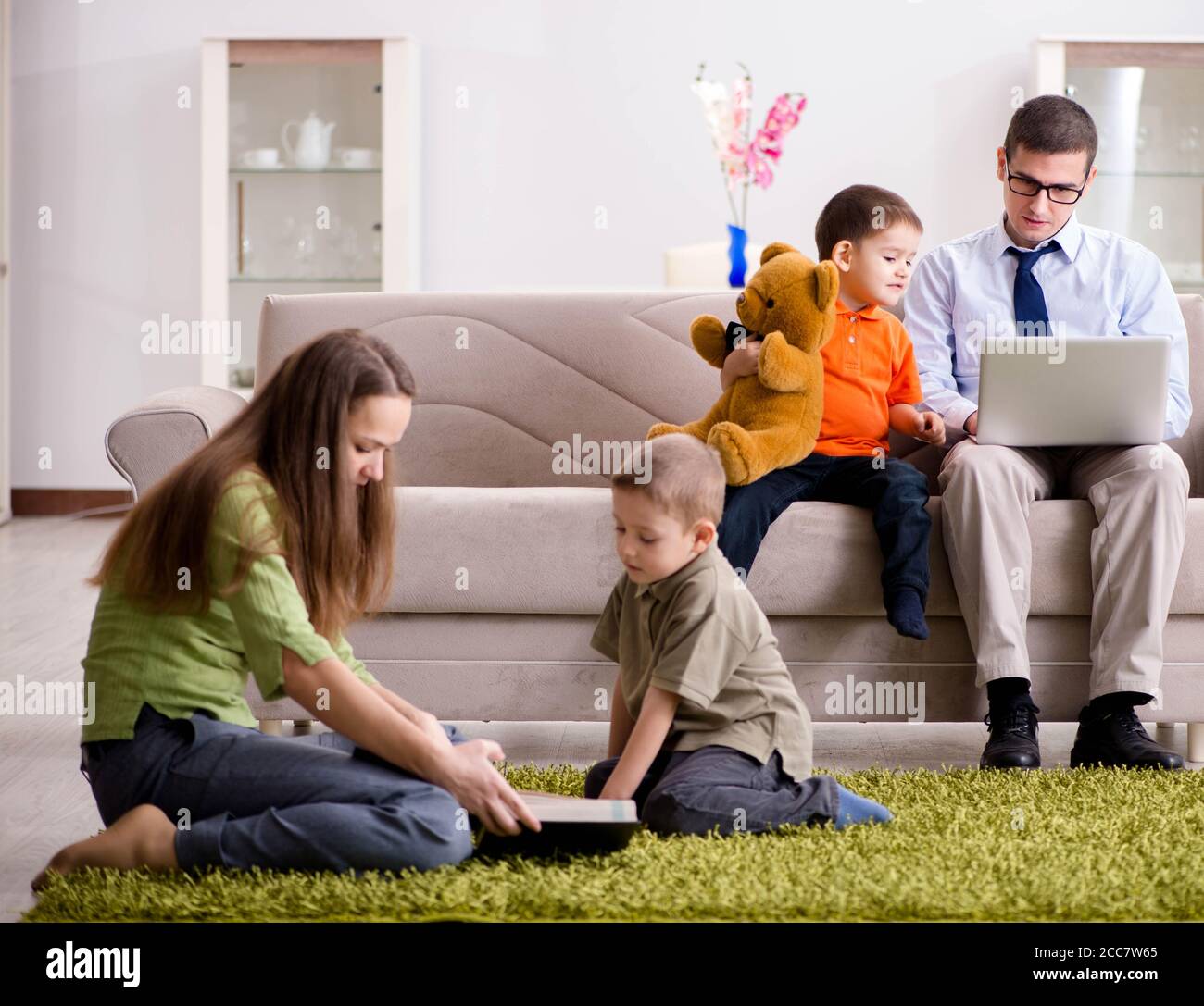 The father is trying to work while children are playing Stock Photo - Alamy