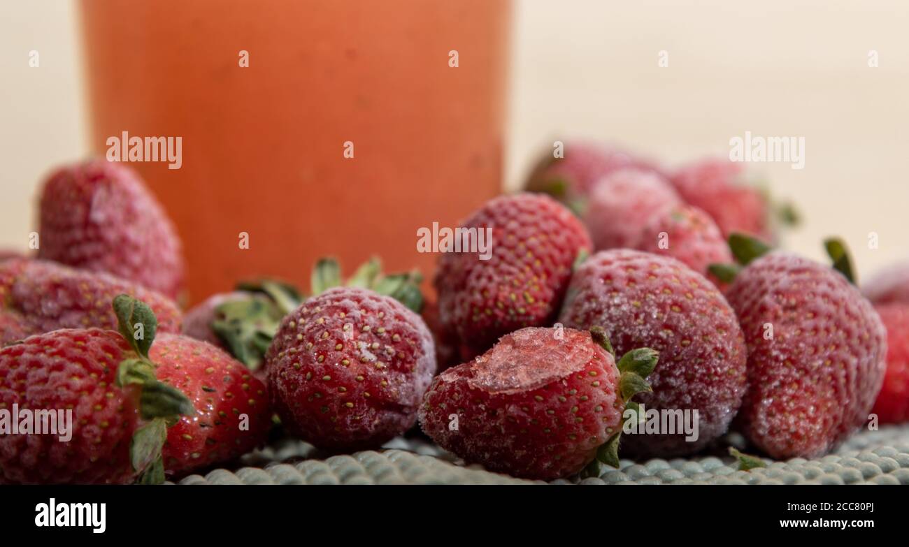 Frozen strawberries. Fresh red fruits. Glass of strawberry juice ...