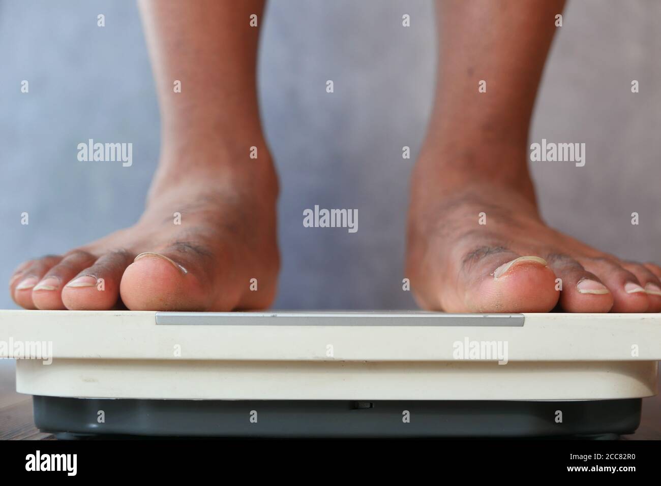 Man's feet on weight scale close up Stock Photo - Alamy