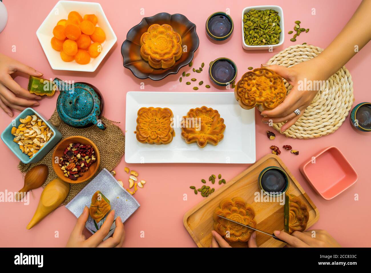 Hands of happy people eating tasty round moon cakes at mid autumn ...