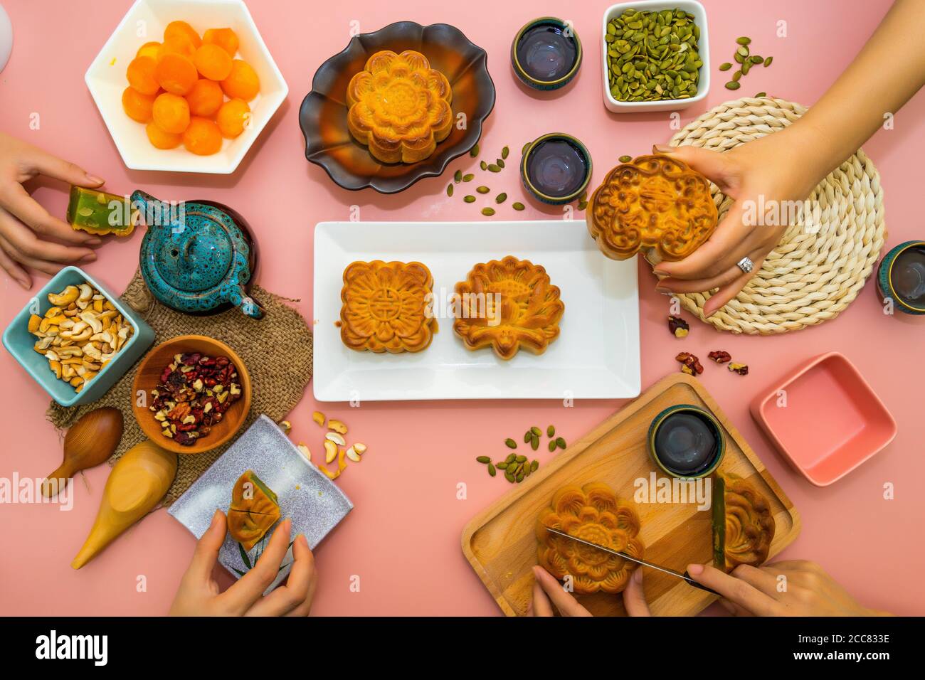 Hands of happy people eating tasty round moon cakes at mid autumn ...