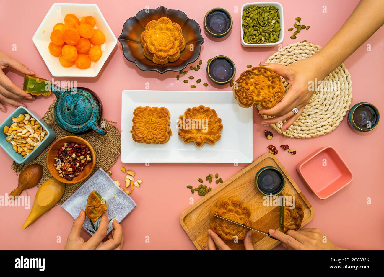 Hands of happy people eating tasty round moon cakes at mid autumn ...