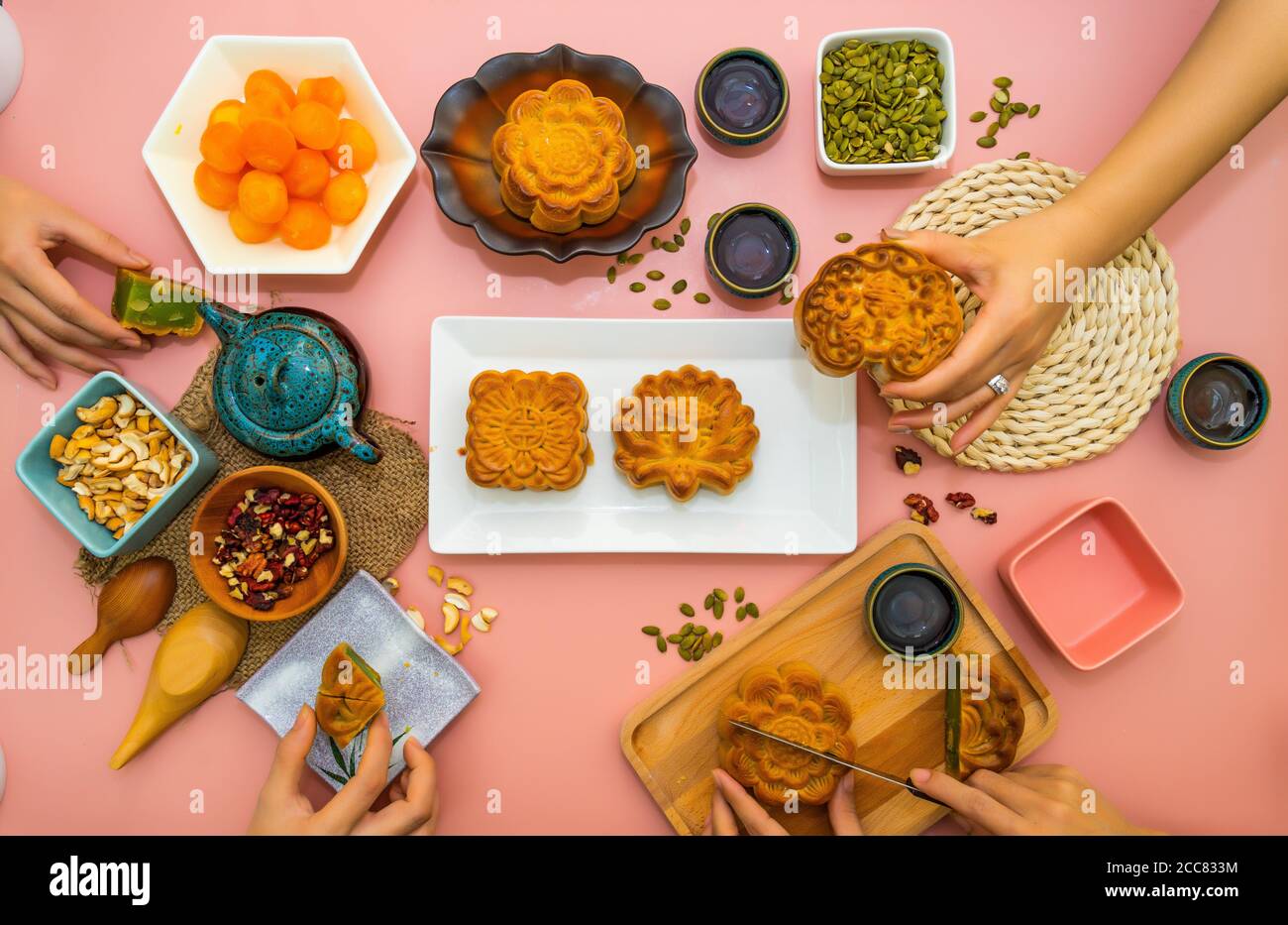 Hands of happy people eating tasty round moon cakes at mid autumn ...