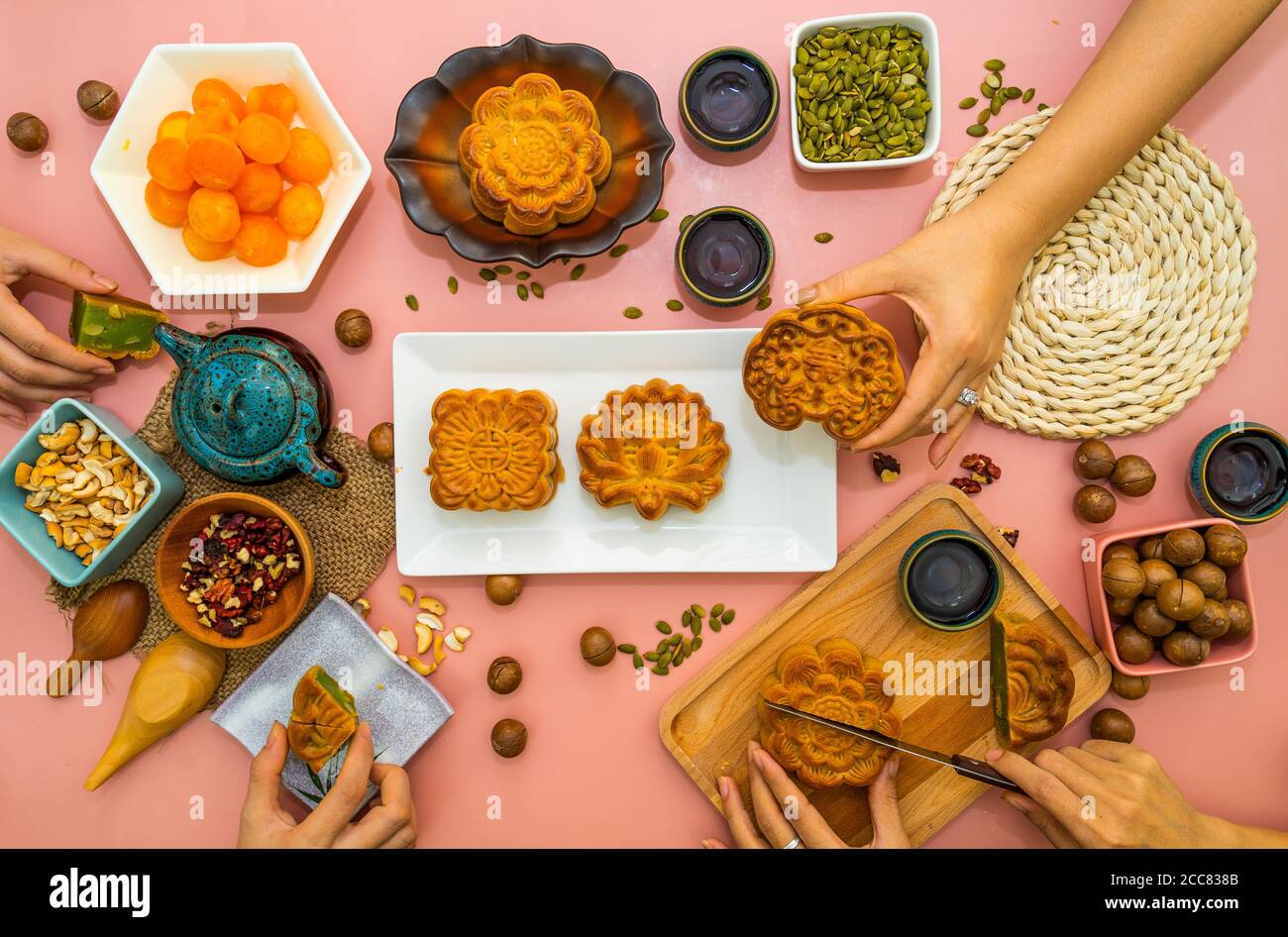 Hands of happy people eating tasty round moon cakes at mid autumn ...