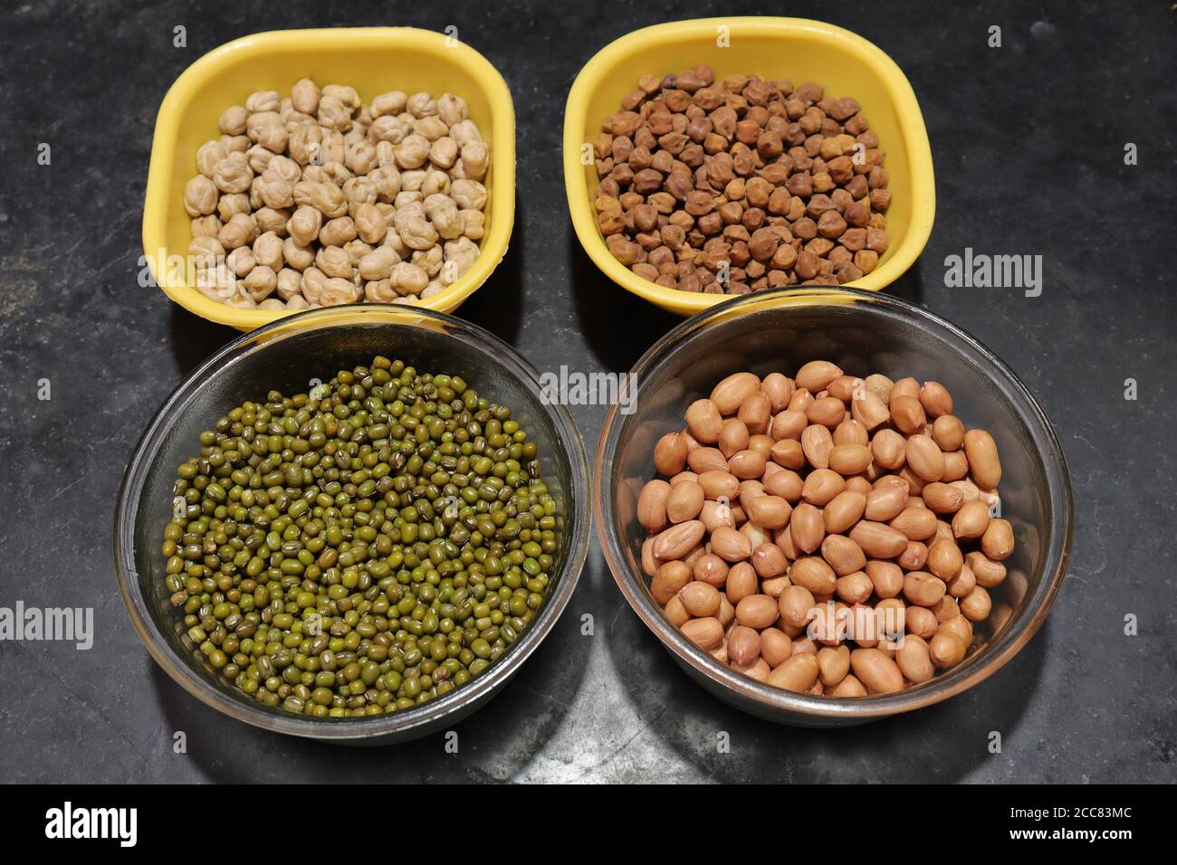 Fresh green gram beans and peanuts with channa on black background ...