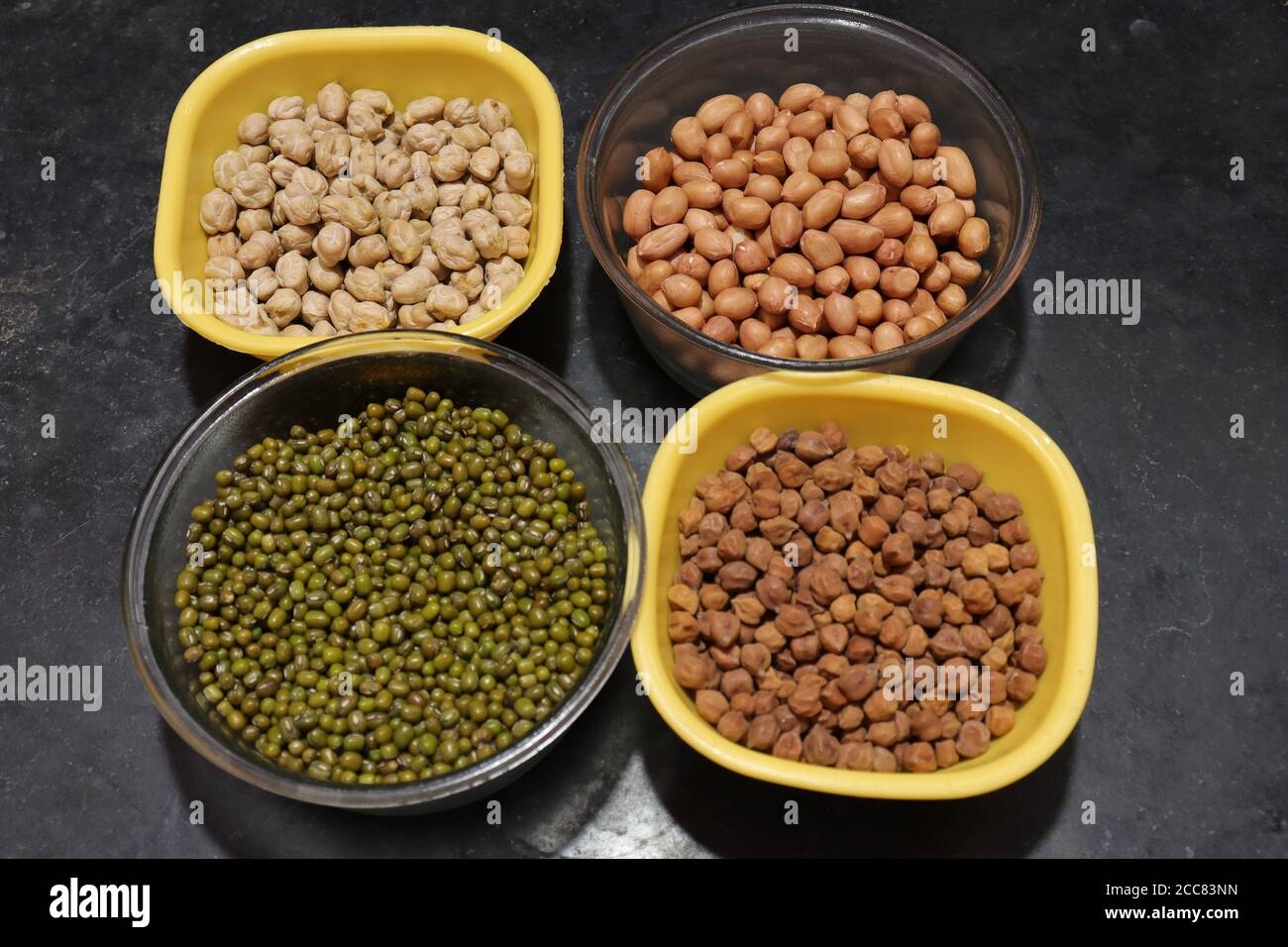 Fresh green gram beans and peanuts with channa on black background ...