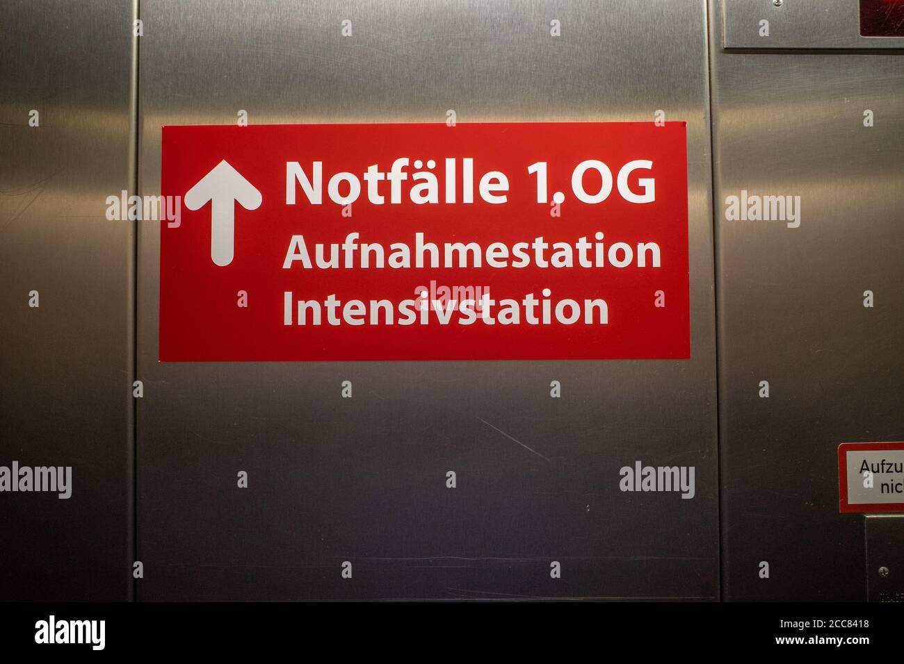 a red sign with white letters indicates emergencies 1st floor ...