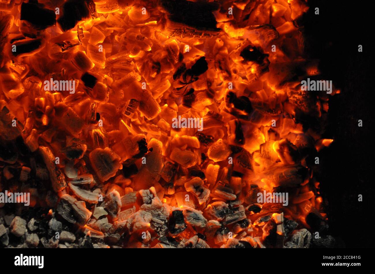 Vibrant red orange color flaming texture with smoldering pieces of ...