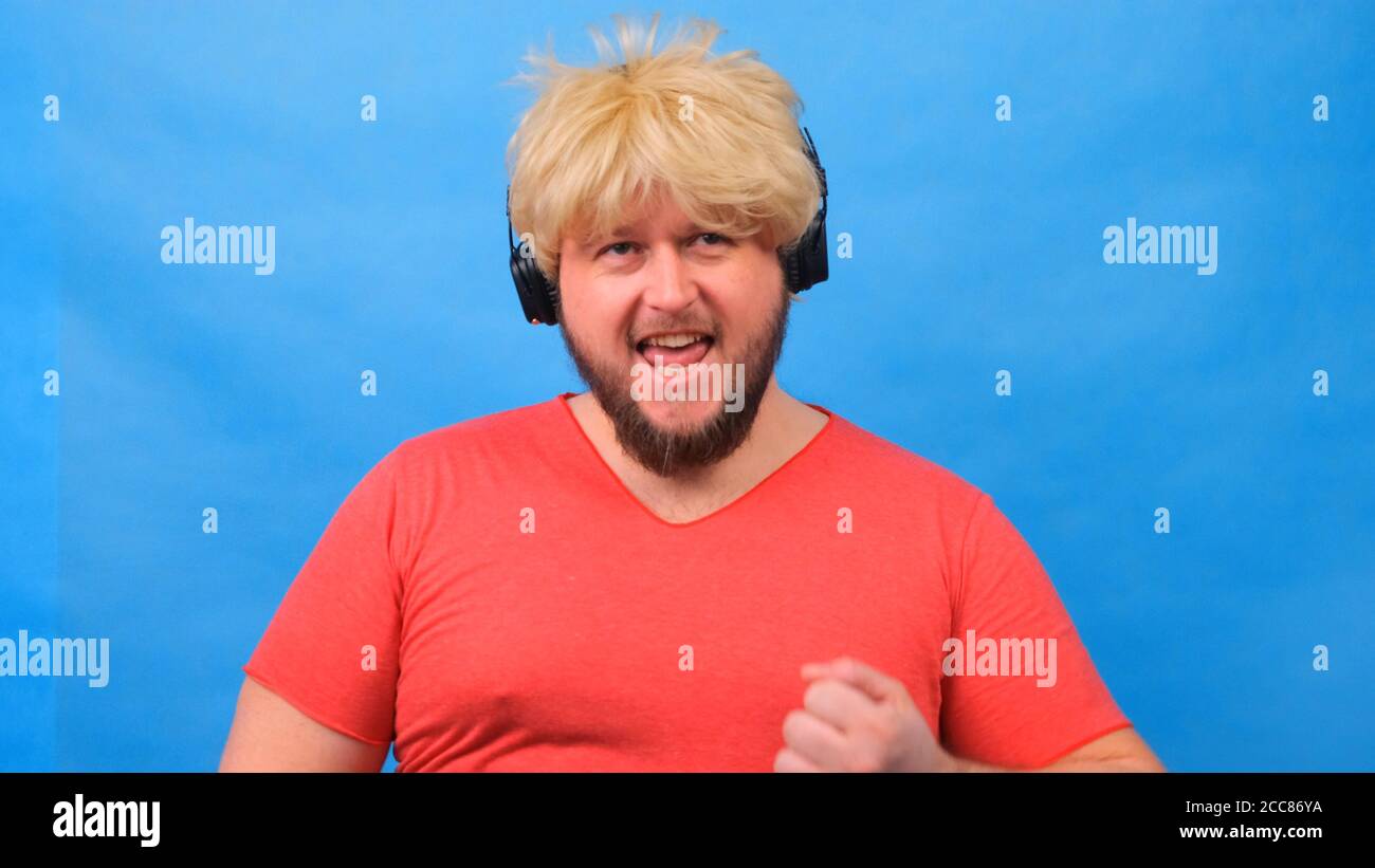 laughing freaky fat man in a wig and a pink T-shirt in his hands ...