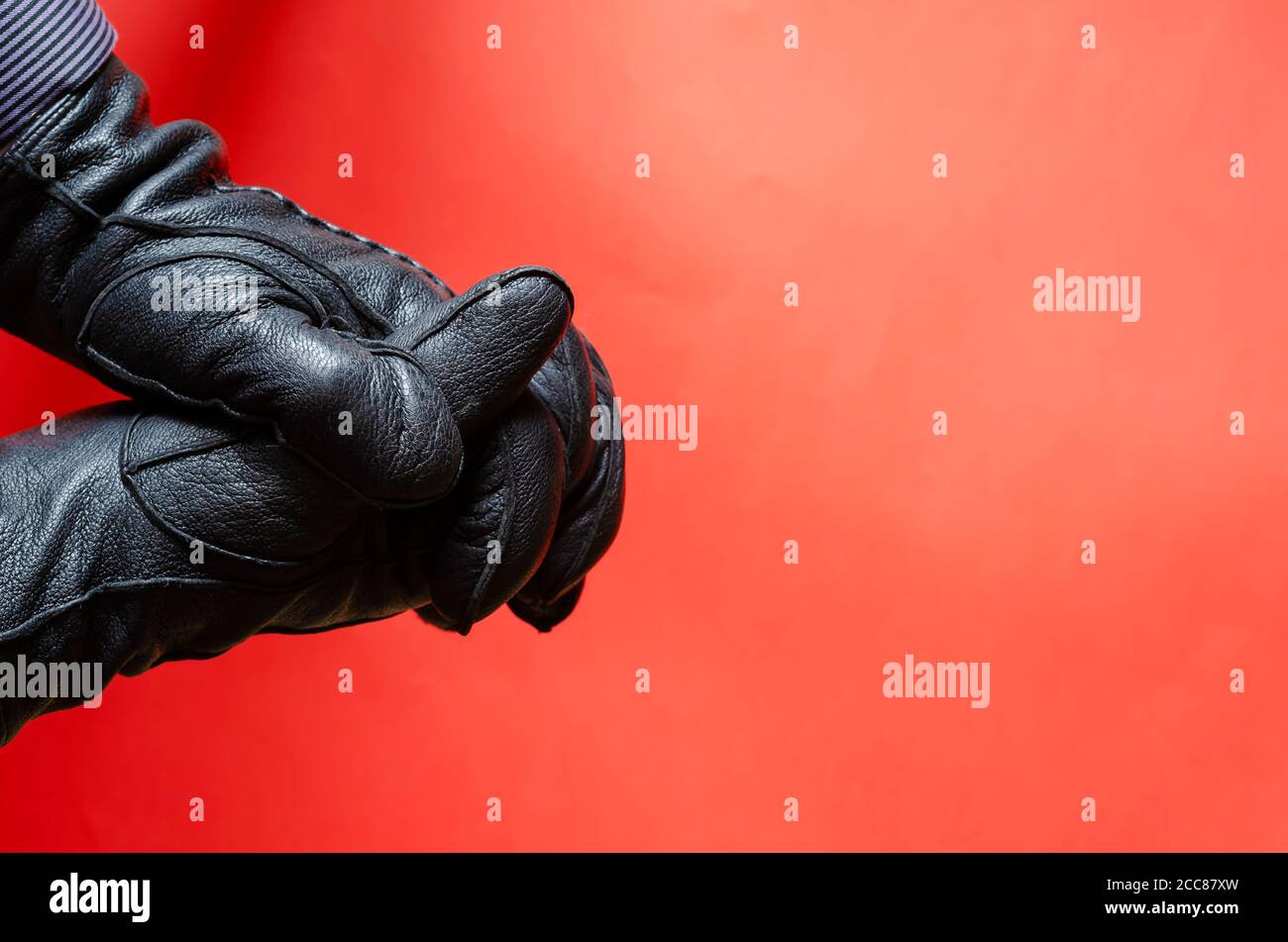 Male hand in leather glove gestures against coral background. Man shows ...
