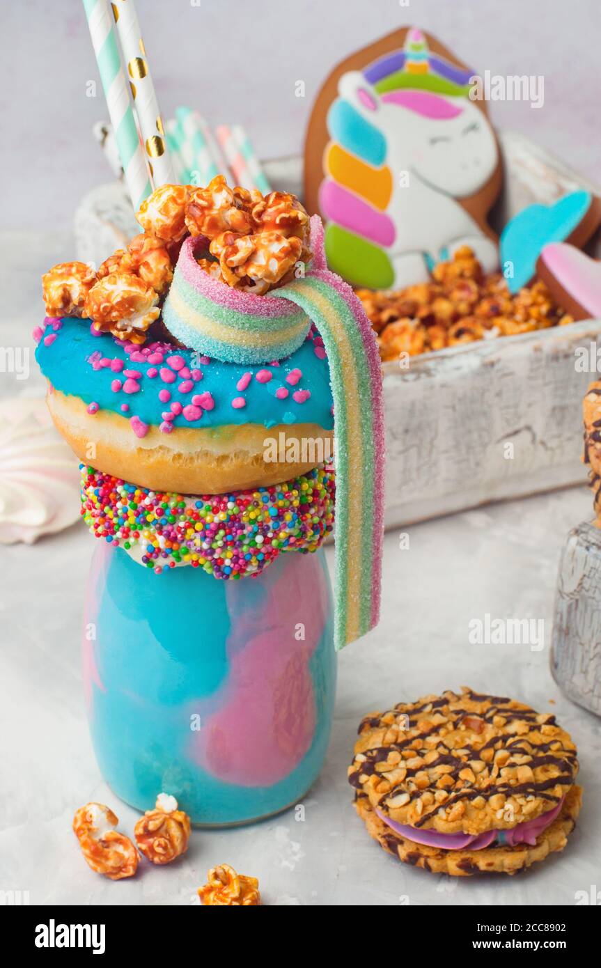 Freak shake topping with donut, popcorn over grey background Stock ...
