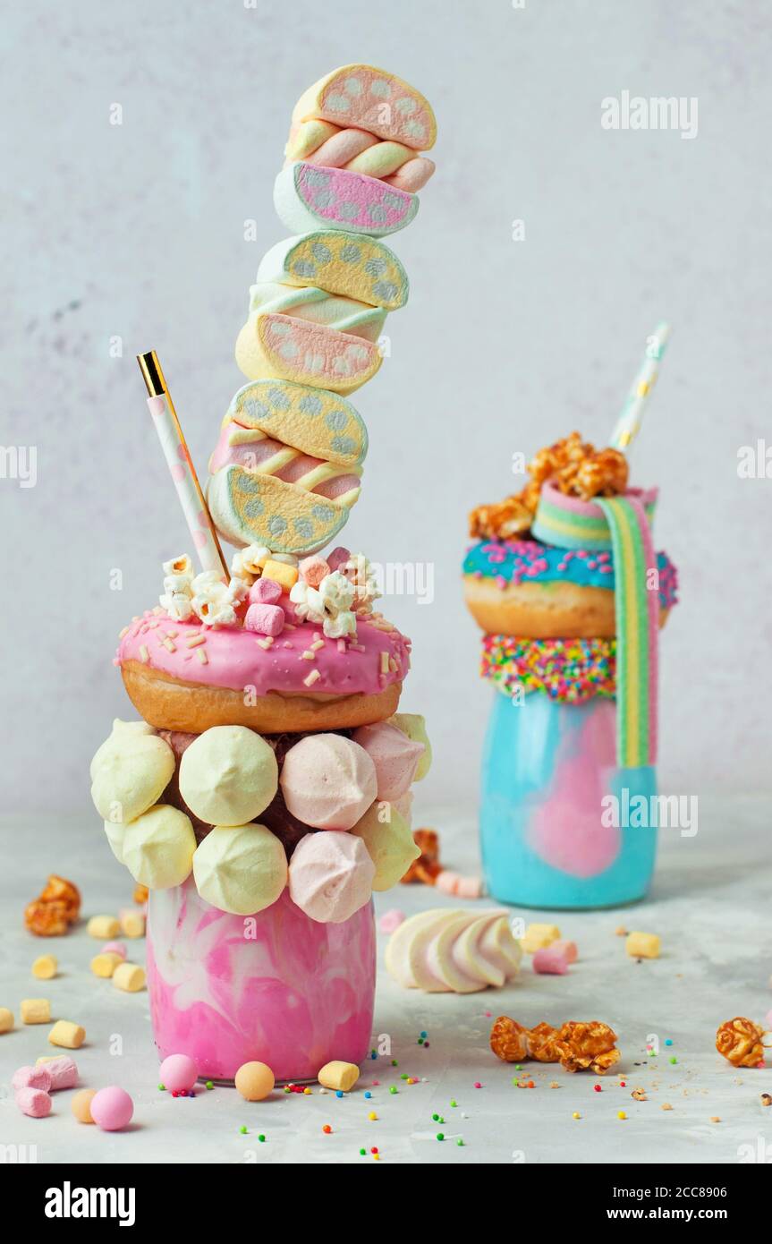 Freak shakes topping with donuts, marshmallow over grey background ...