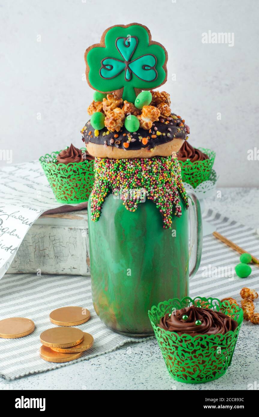 Green freak shake topping with clover gingerbread cookie on grey ...