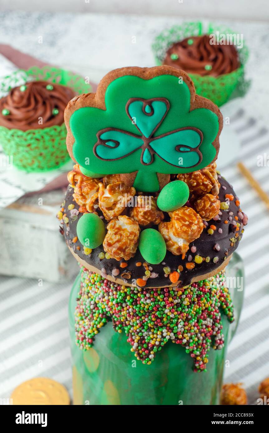 Close up of green freak shake topping with clover and rainbow cookies ...
