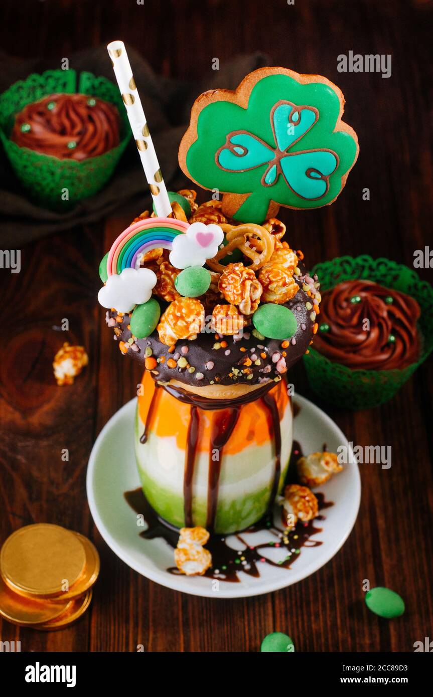 Irish flag color freak shake topping with clover cookie on wooden ...