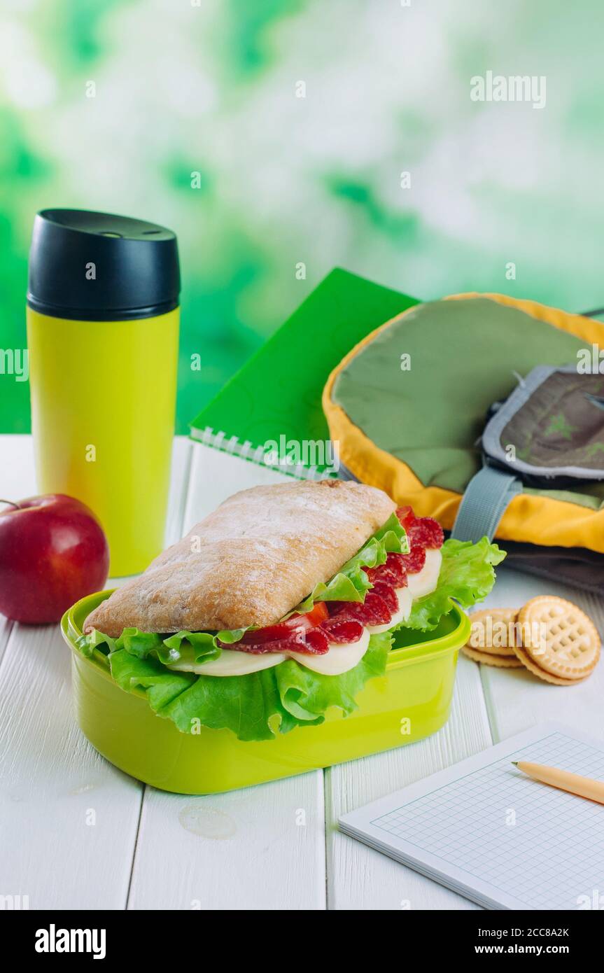 Lunch box with sandwich near thermos mug and pen on office table Stock ...