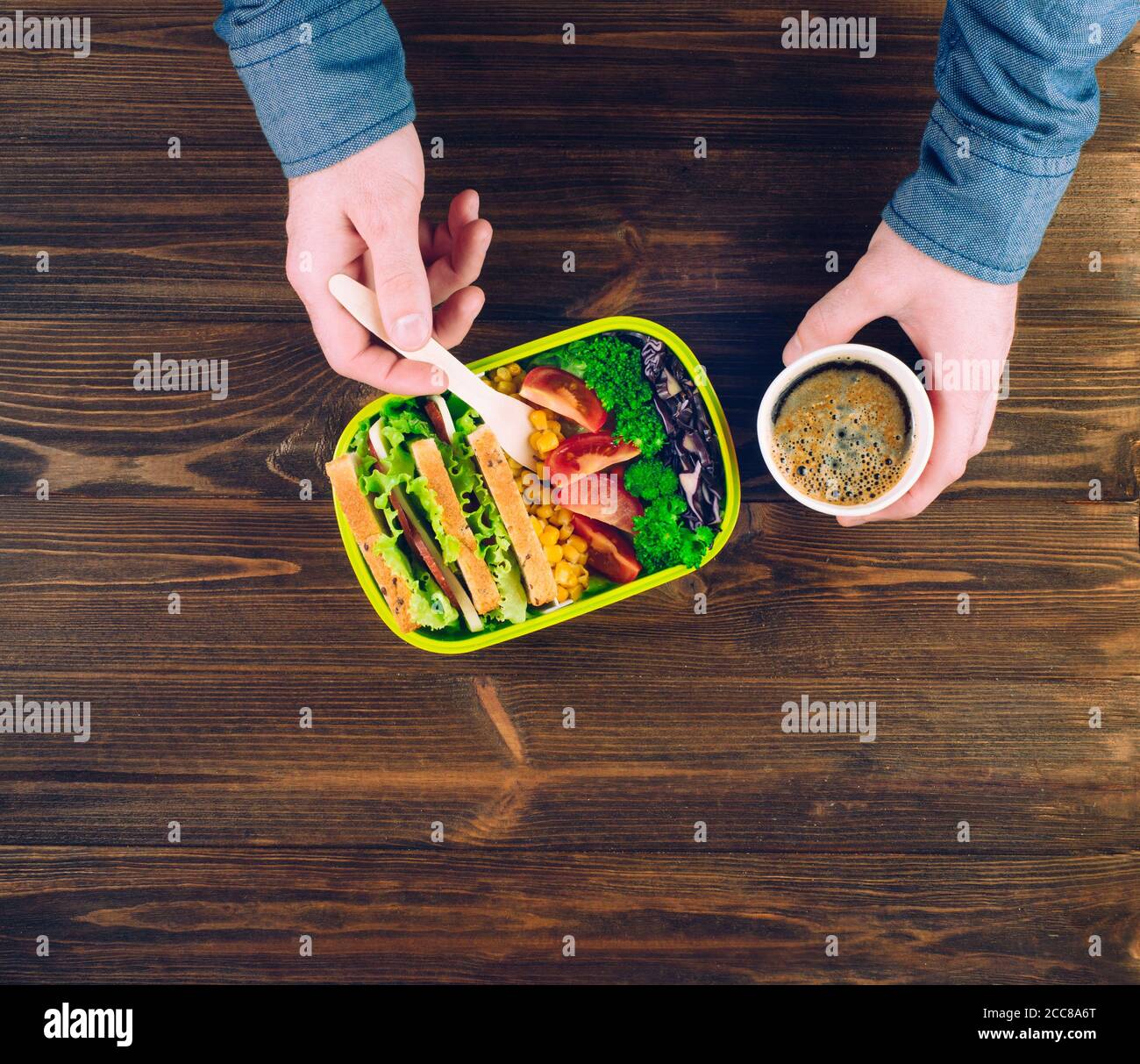 Males hands eating his lunch from lunchbox on rustic background Stock ...