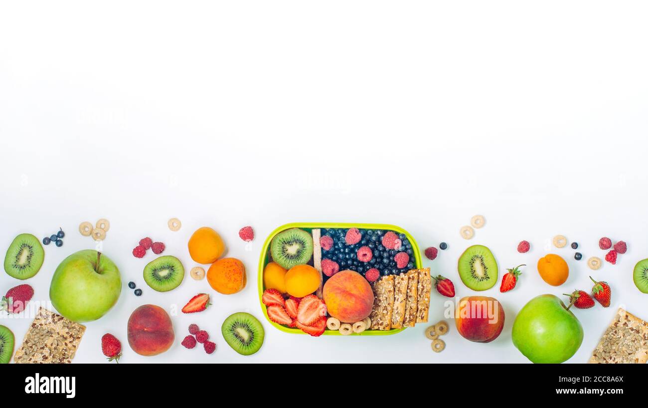 Frame with lunch box and various fruits, berries and crunches on white ...