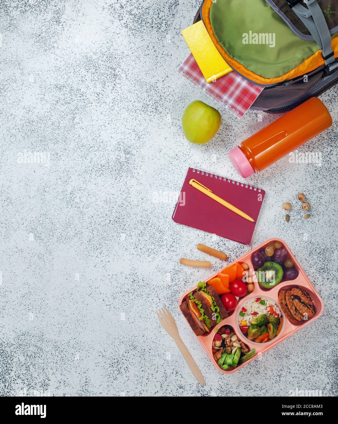 Open lunch box with healthy food on the grey background near school ...