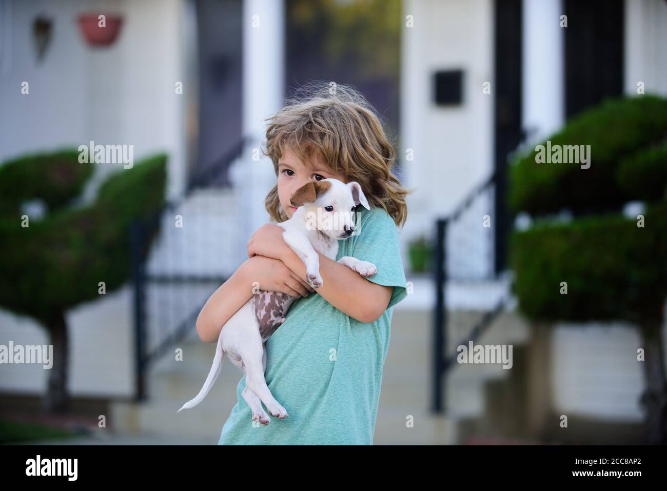 Funny photo of happy kids hugging beautiful puppy dog. Lovely child ...