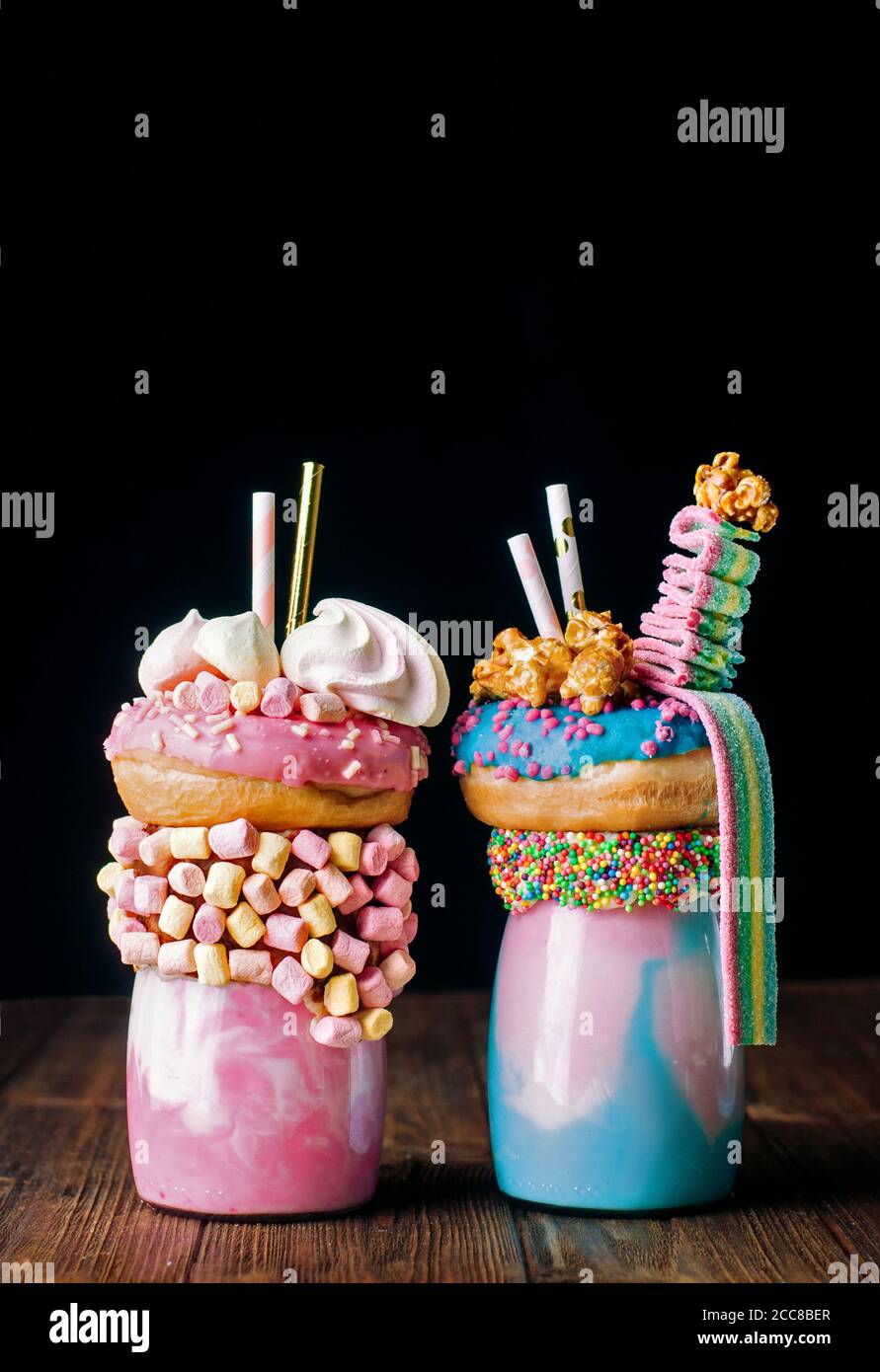 Two freak shakes topping over black background with blank space for ...