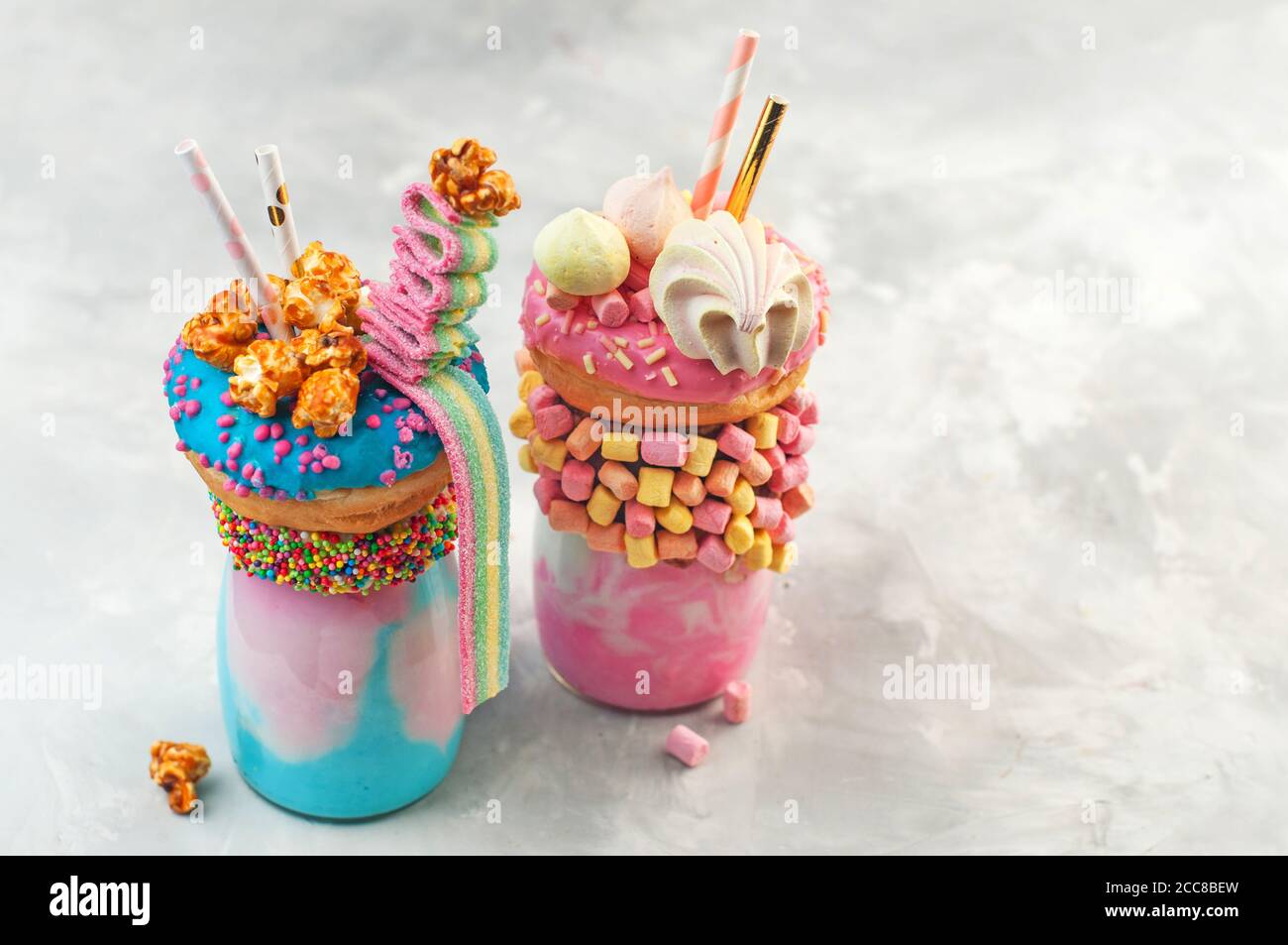 Two color freak shakes topping with donuts over grey background Stock ...