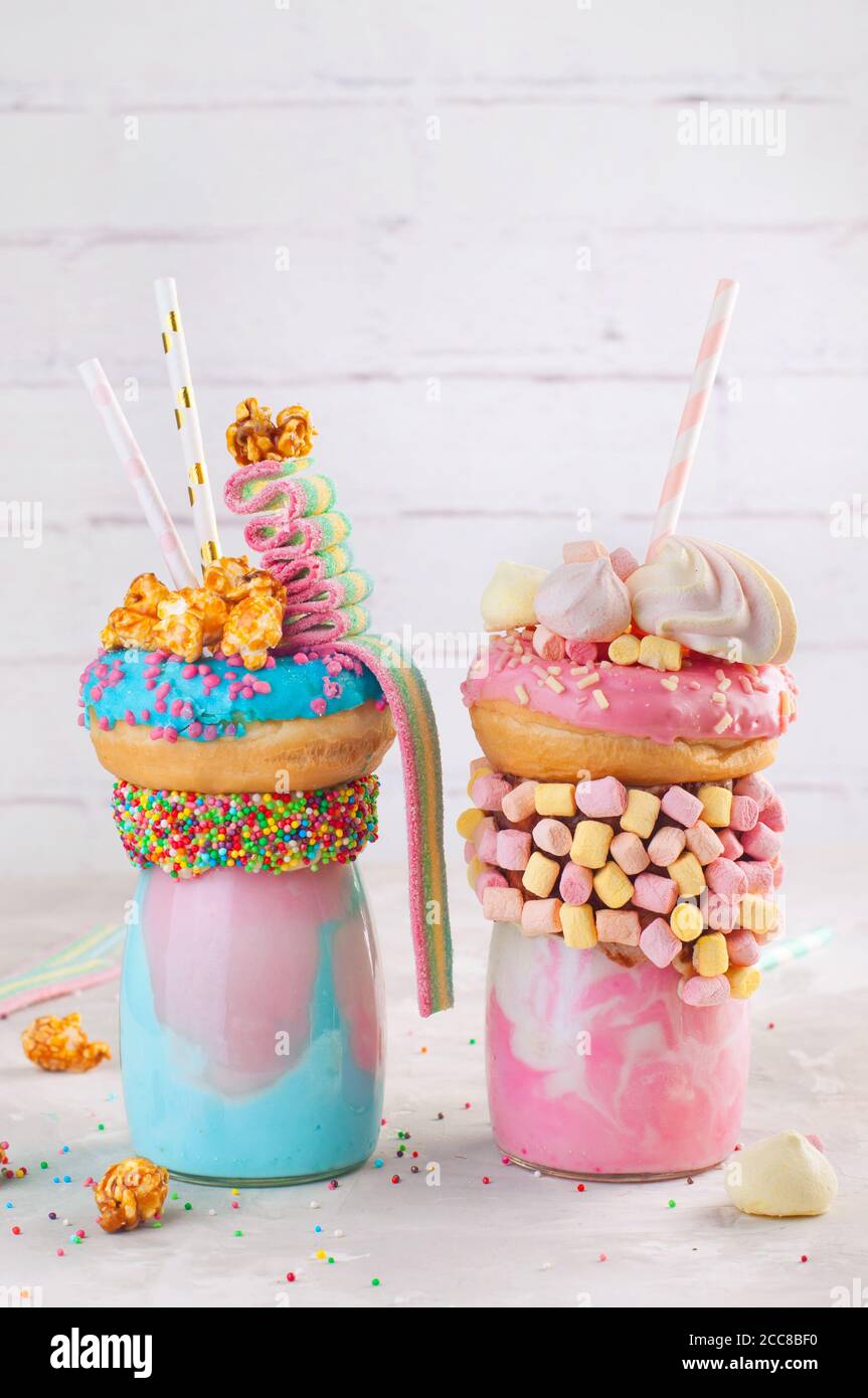 Two freak shake topping with donut and marmalade over grey background ...
